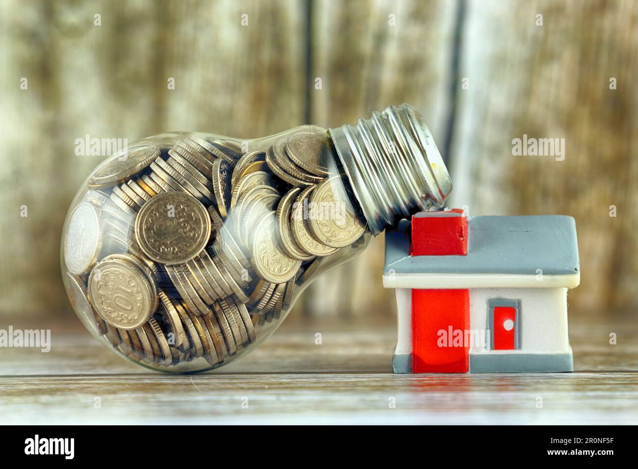 Coins inside the light bulb and miniature house. Green eco renewable ...