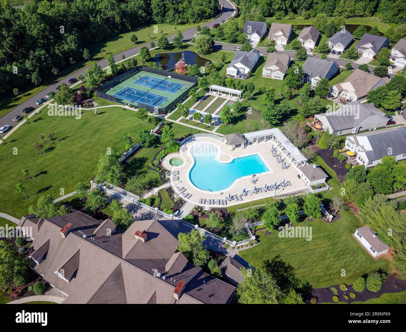 A serene backyard featuring a large swimming pool and a tennis court ...