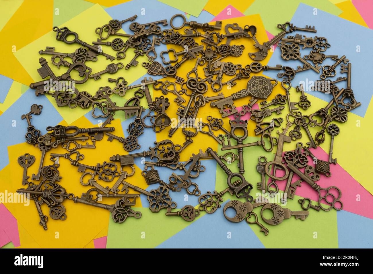 Bronze ornamental keys on a background of multicolored paper sticky ...