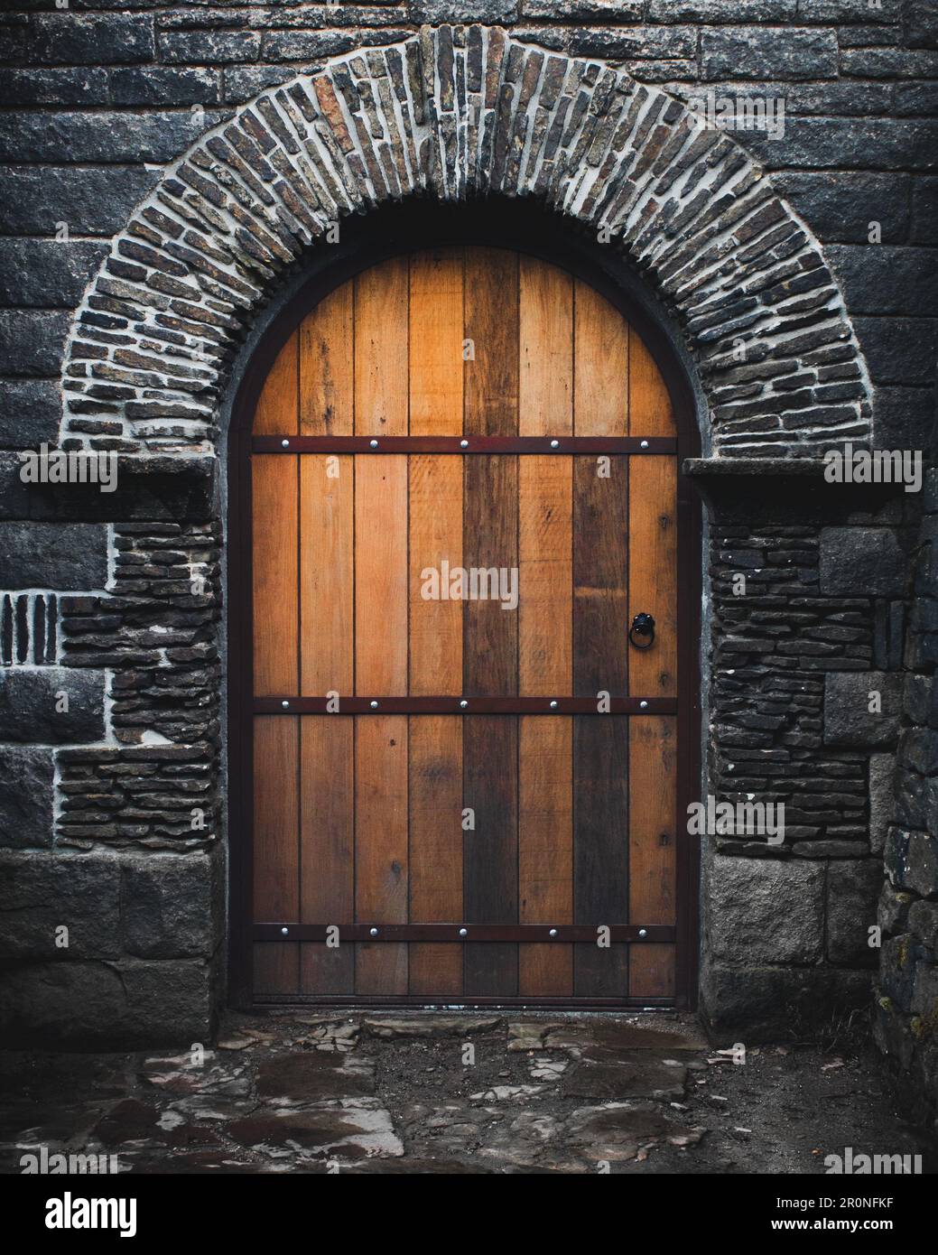 A restored vibrant orange wooden castle arch door surrounded by ...
