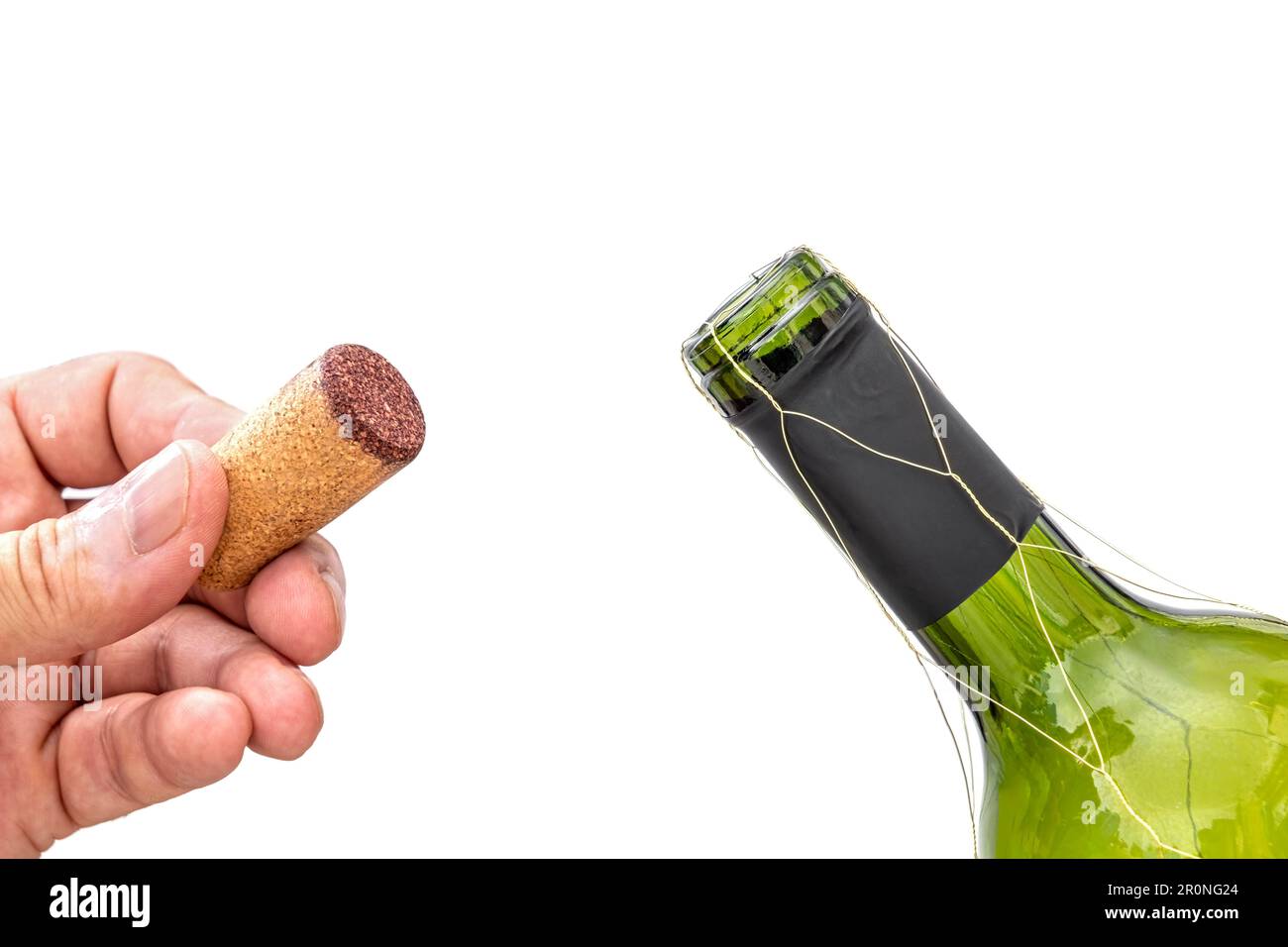 wine bottle isolated against white with hand holding the stopper by the ...