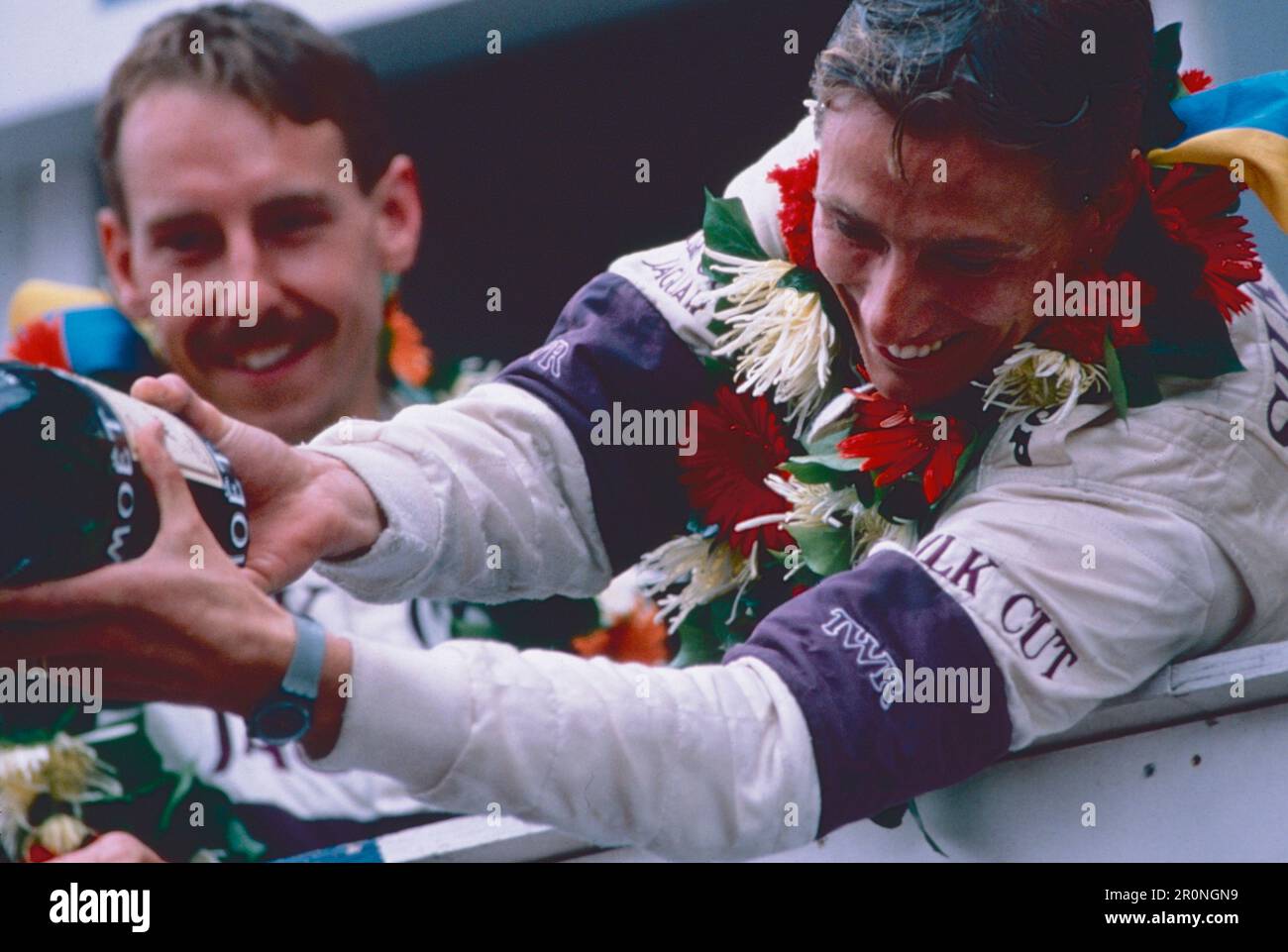 Racing driver of the Jaguar XJ220 racing car team pouring champagne at ...