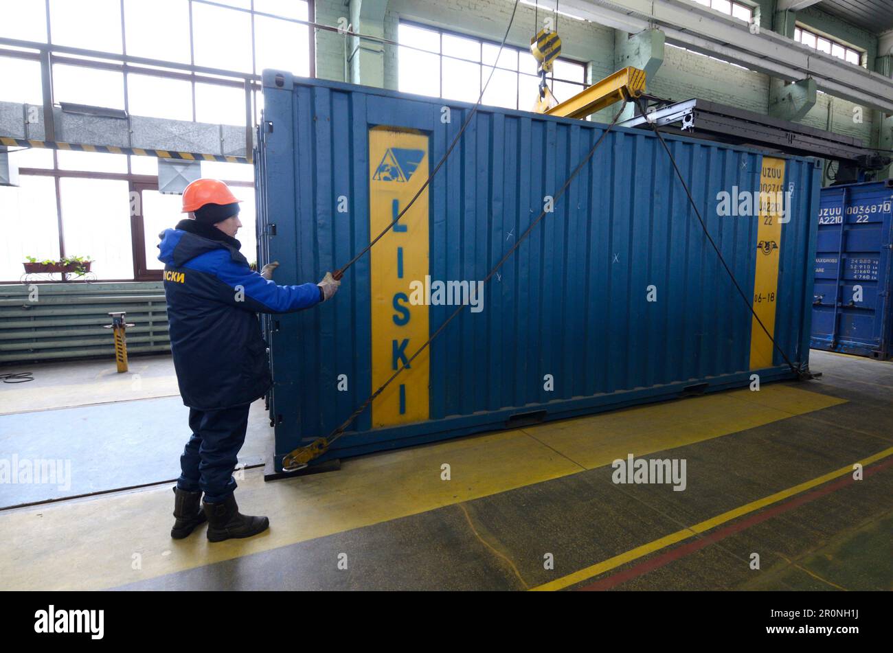 Man worker lifting cargo container for repairing using the hoist crane ...