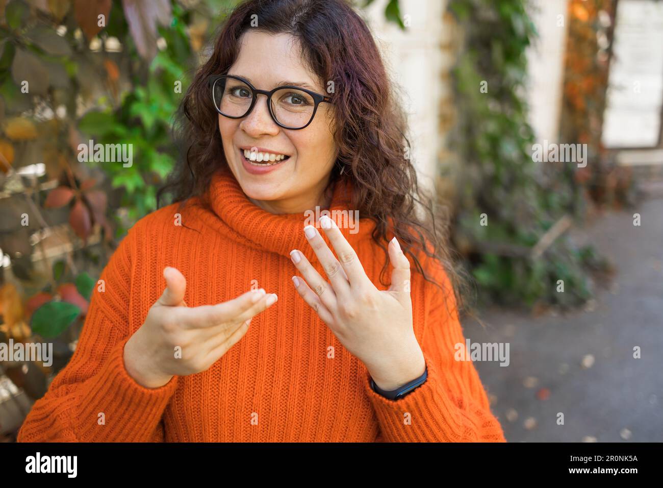 Happy curly woman blogger smiling face talking to webcam recording vlog ...