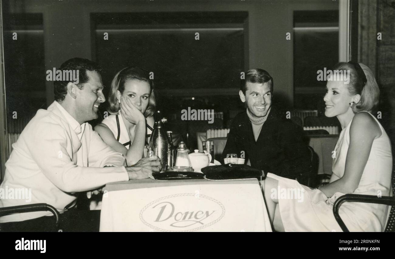 German twin entertainers Alice and Ellen Kessler sitting at a table of ...