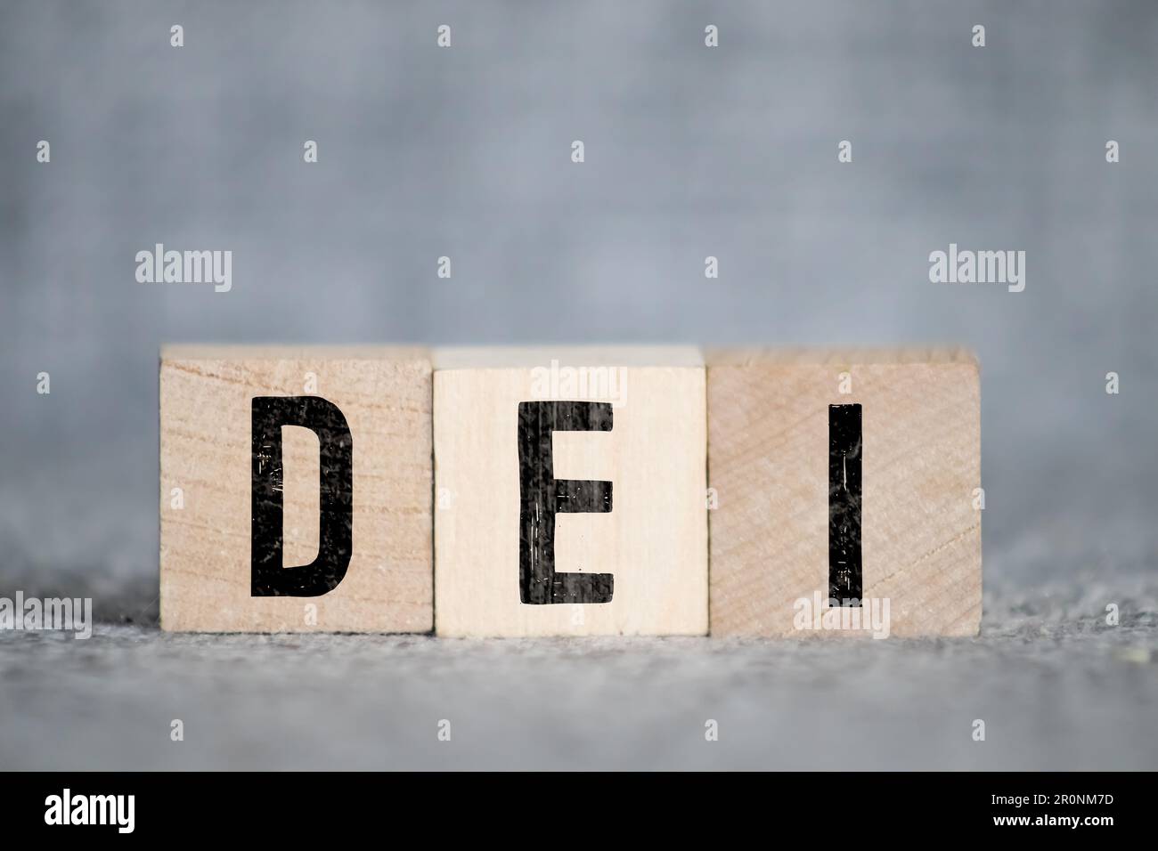 wooden blocks with text DEI on yellow background. dei - short for ...