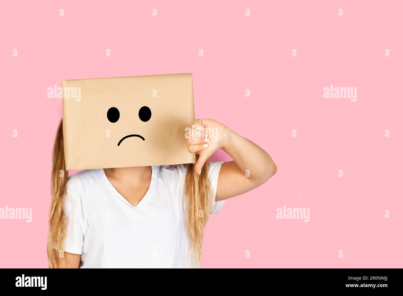 Woman with her head in a box, sad gesture and thumb down standing on a ...