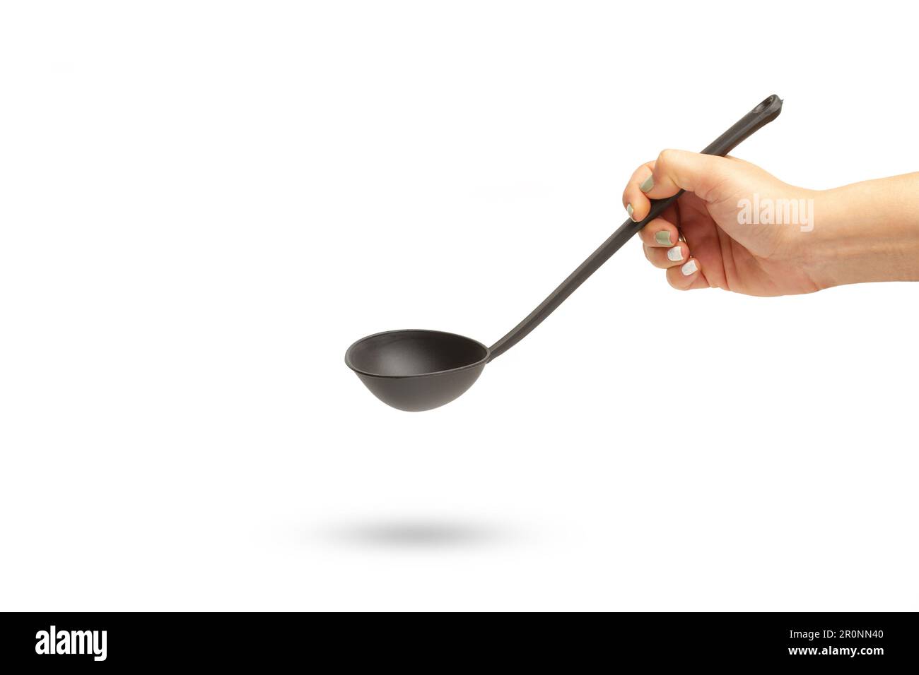 Woman hand holding a black plastic ladle on a white background with ...