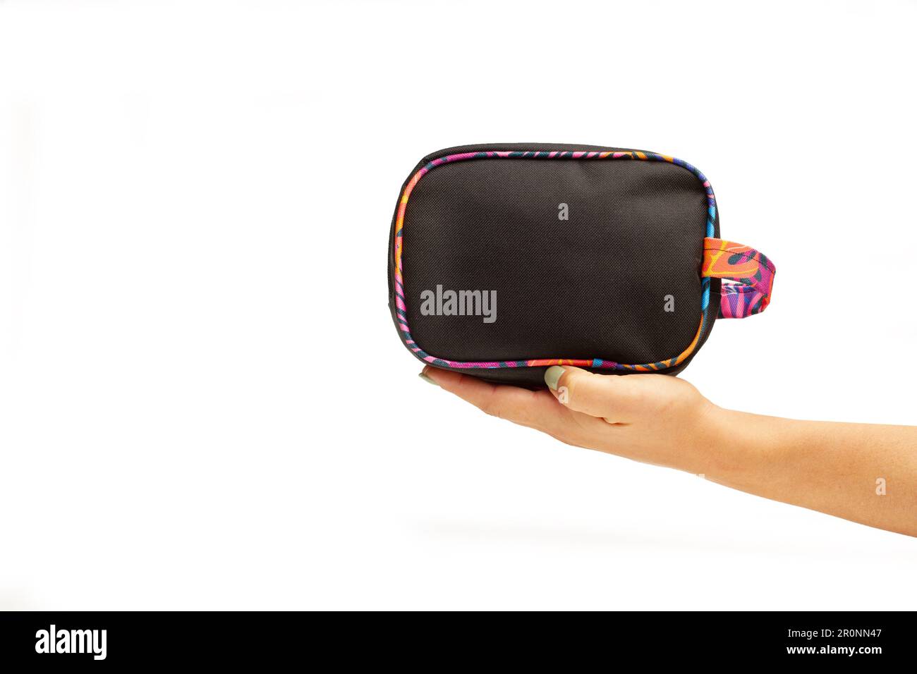 Woman hand holding a black pouch with handle on a white background with ...