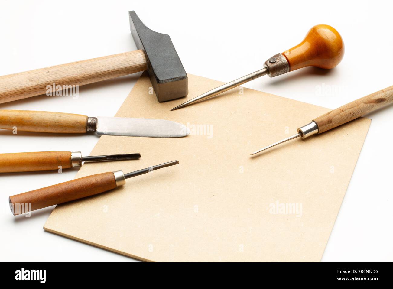 Hammer, awl and gouges with wooden handles on a pieces of wood and on a ...