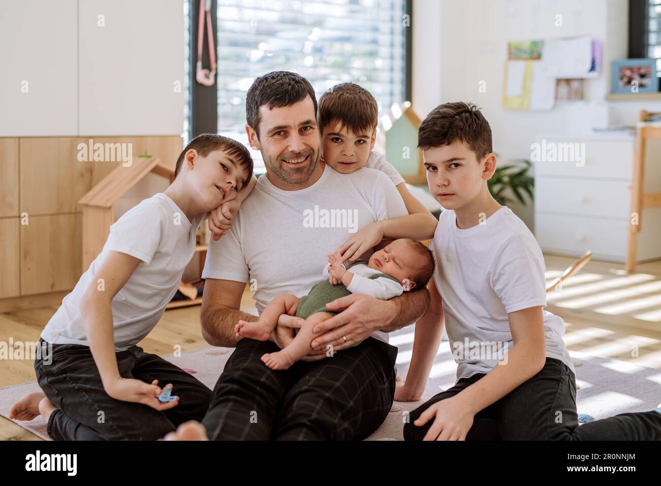Portrait of father and his four sons, holding his newborn baby Stock ...