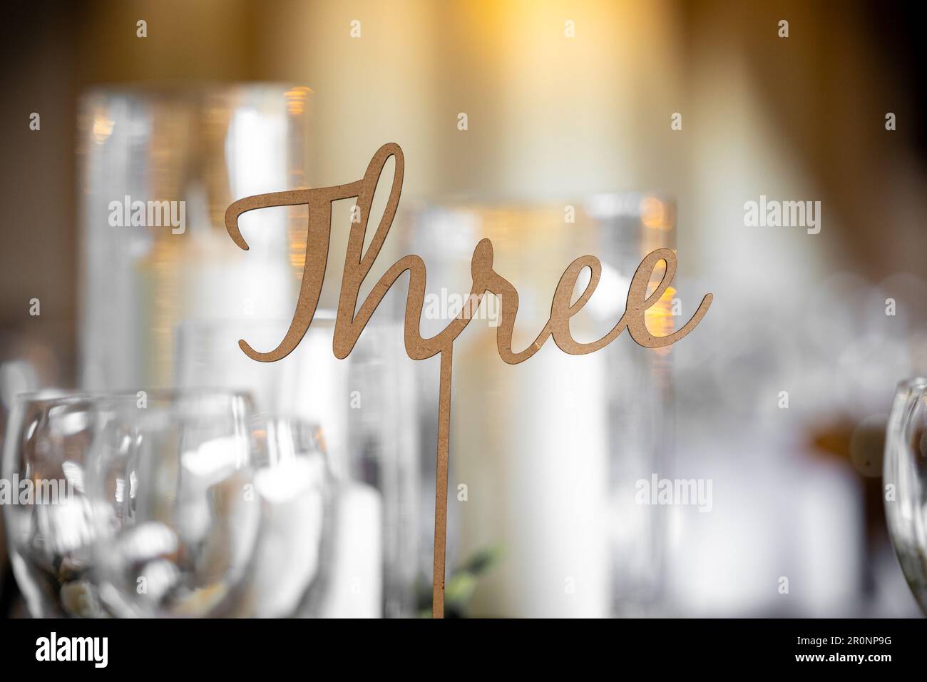 Table number three wooden sign with romantic dinner setting blurred ...