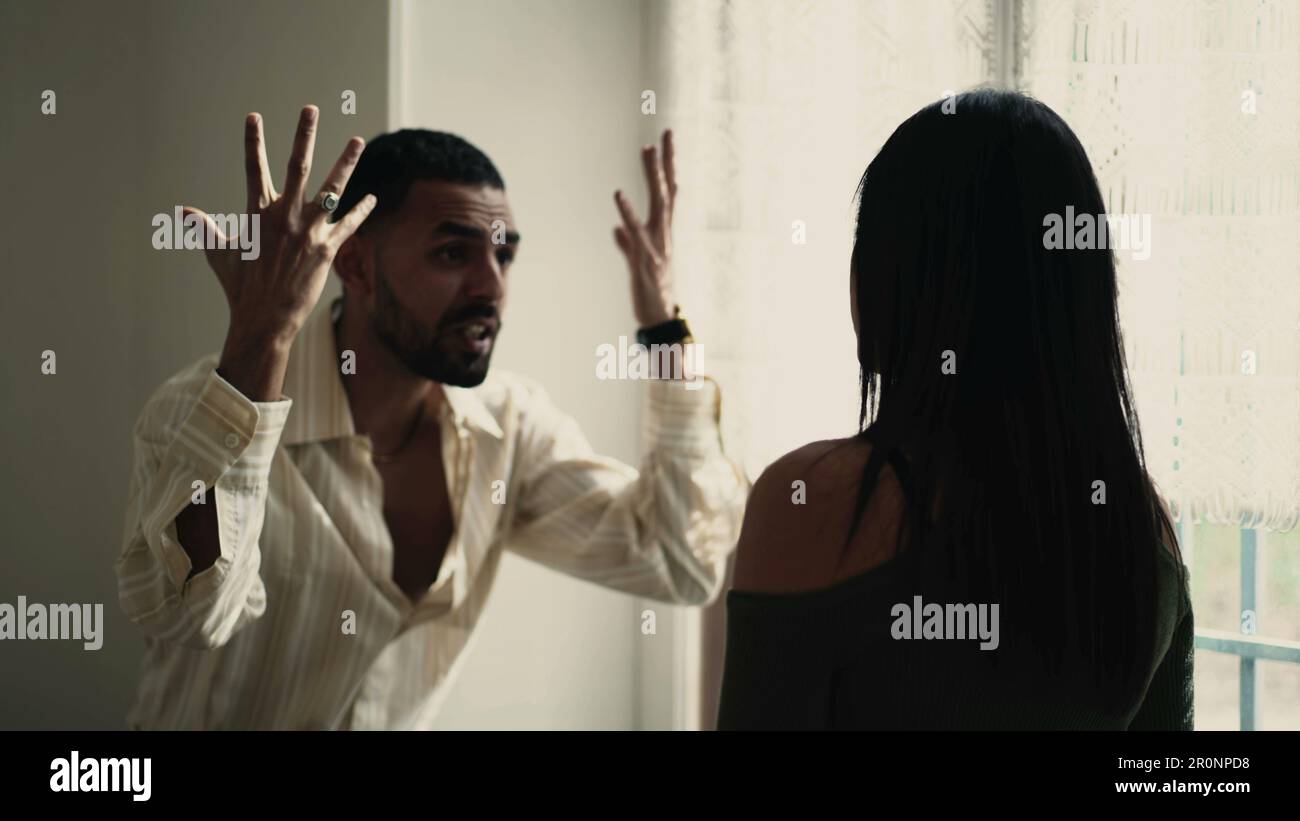 Angry man arguing with girlfriend by window at home. Male person ...