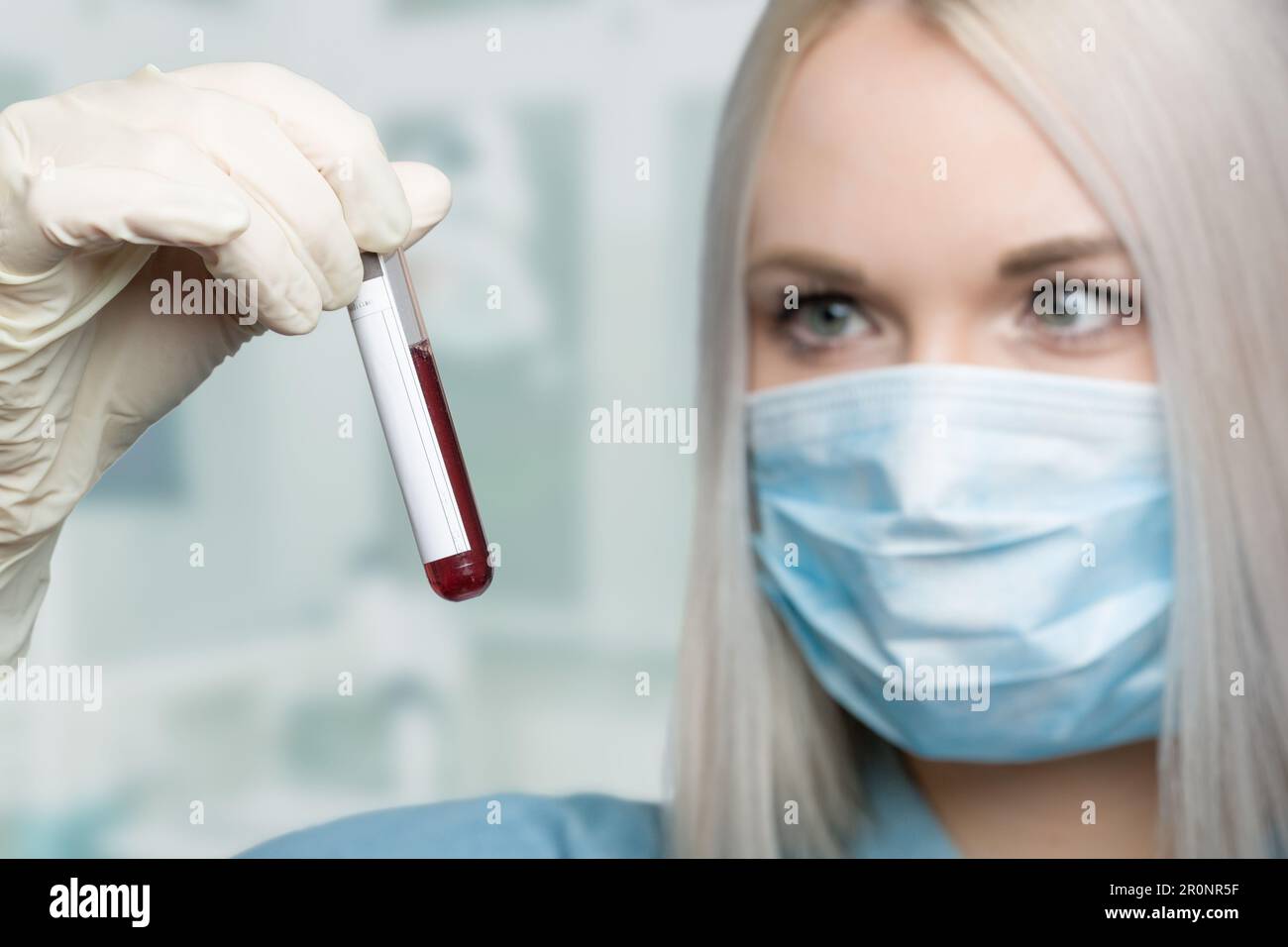 female scientist is handling a blood test tube in front of a laboratory ...