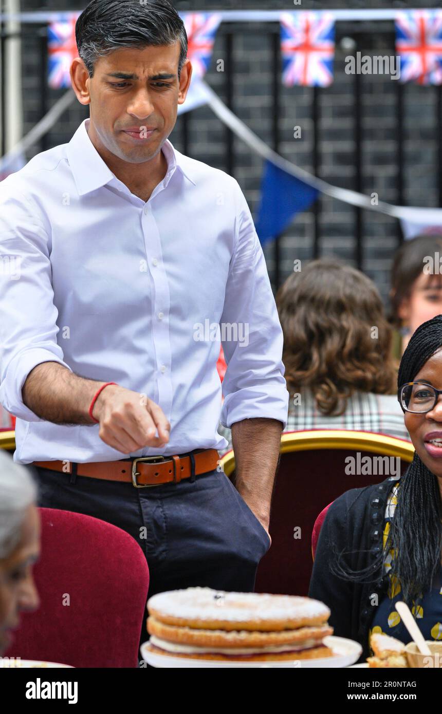 Prime Minister Rishi Sunak pointing uncertainly at a cake during the ...
