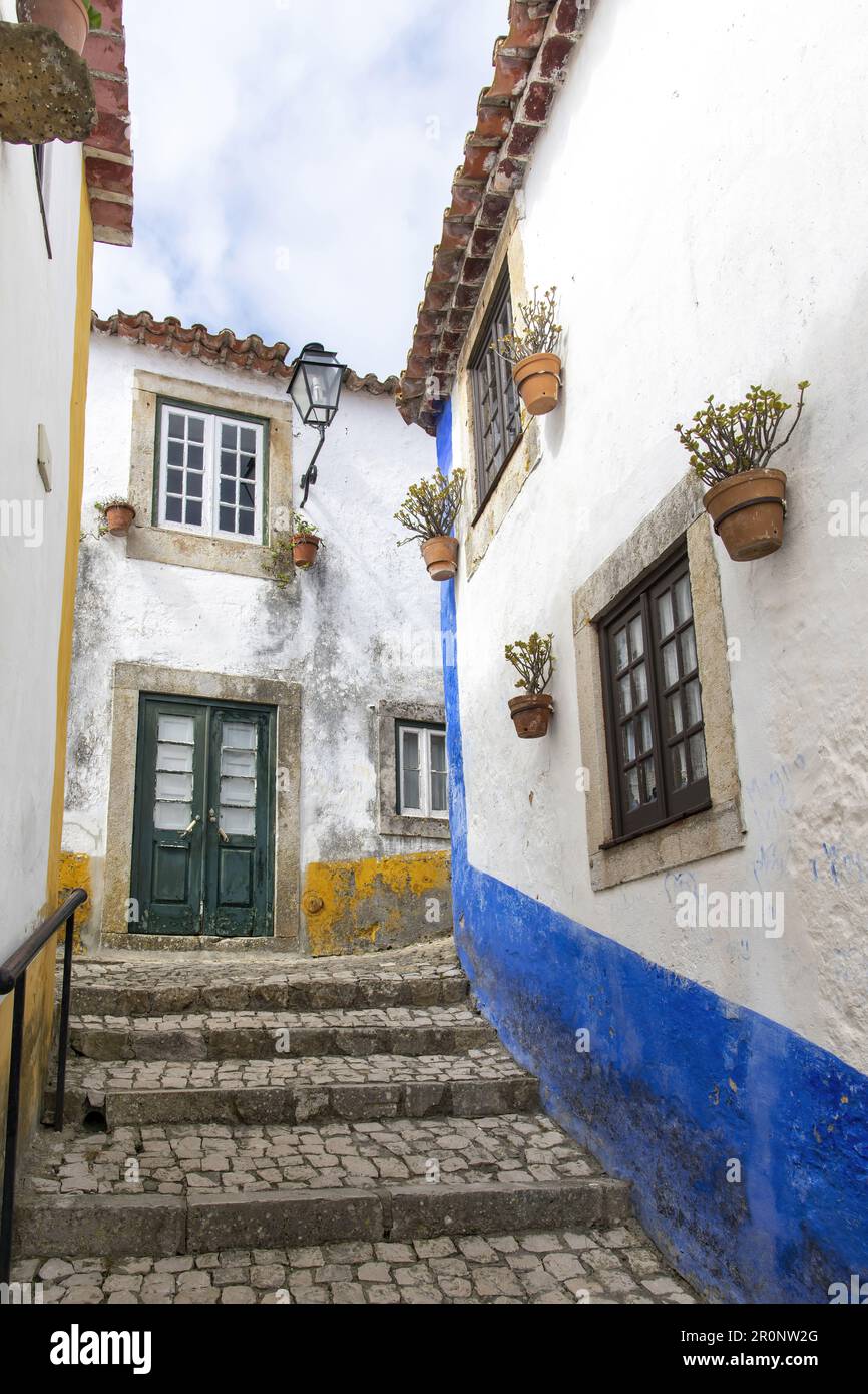 Low angle view over one of the cobblestone streets of Obidos, Portugal ...