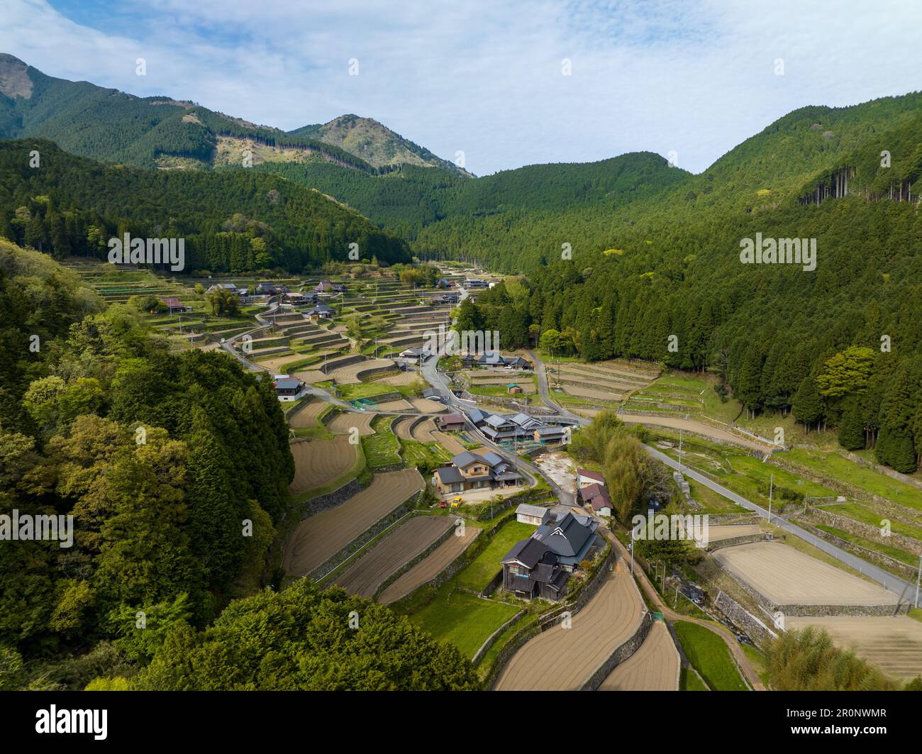 Traditional homes and terraced rice fields in green forested mountains ...