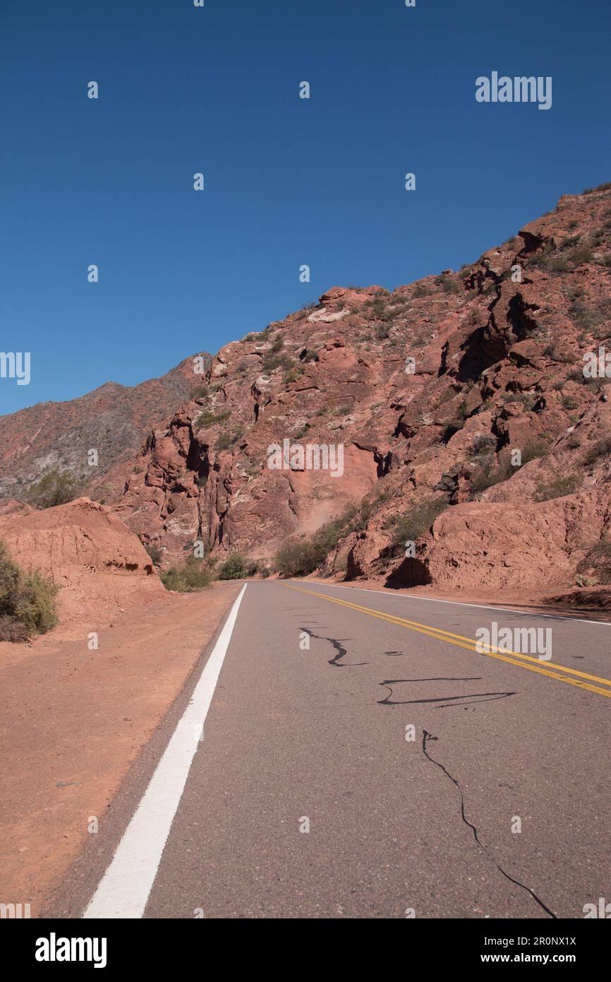 A picturesque desert landscape featuring a winding road snaking between ...