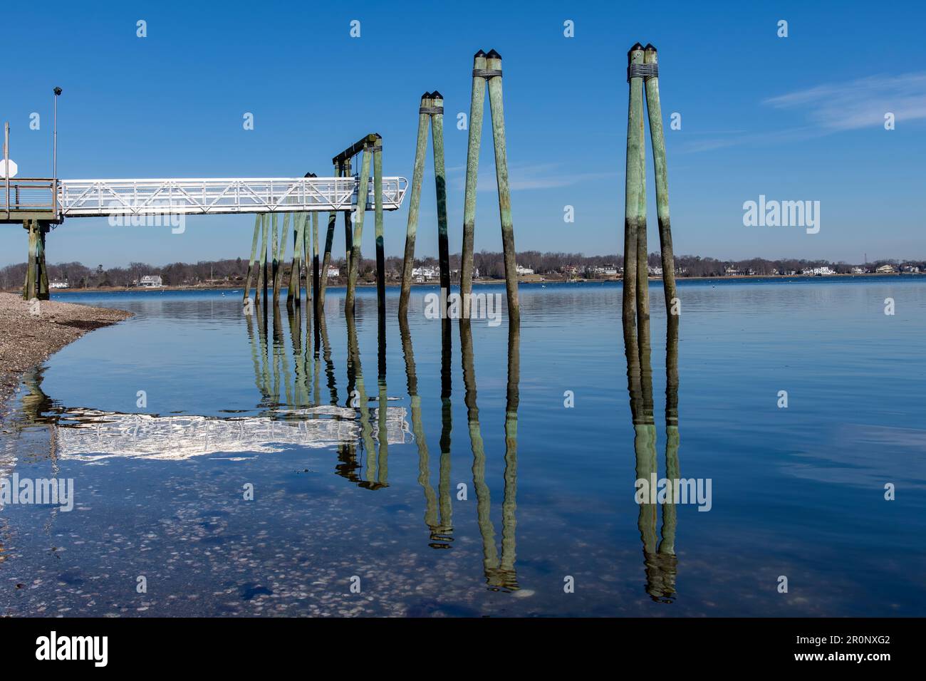 Low angle view of pier with bridge and long row of mooring poles rising ...