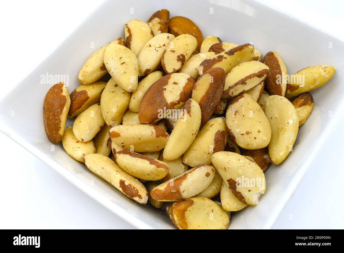Close up of a dish of Brazil nuts on a plain white background Stock ...