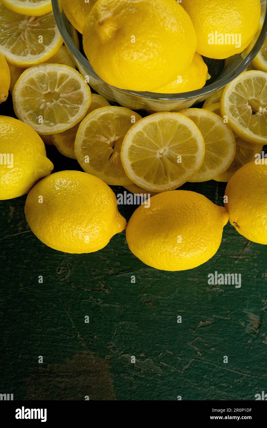 whole and sliced lemons arranged in a circular pattern on a green ...