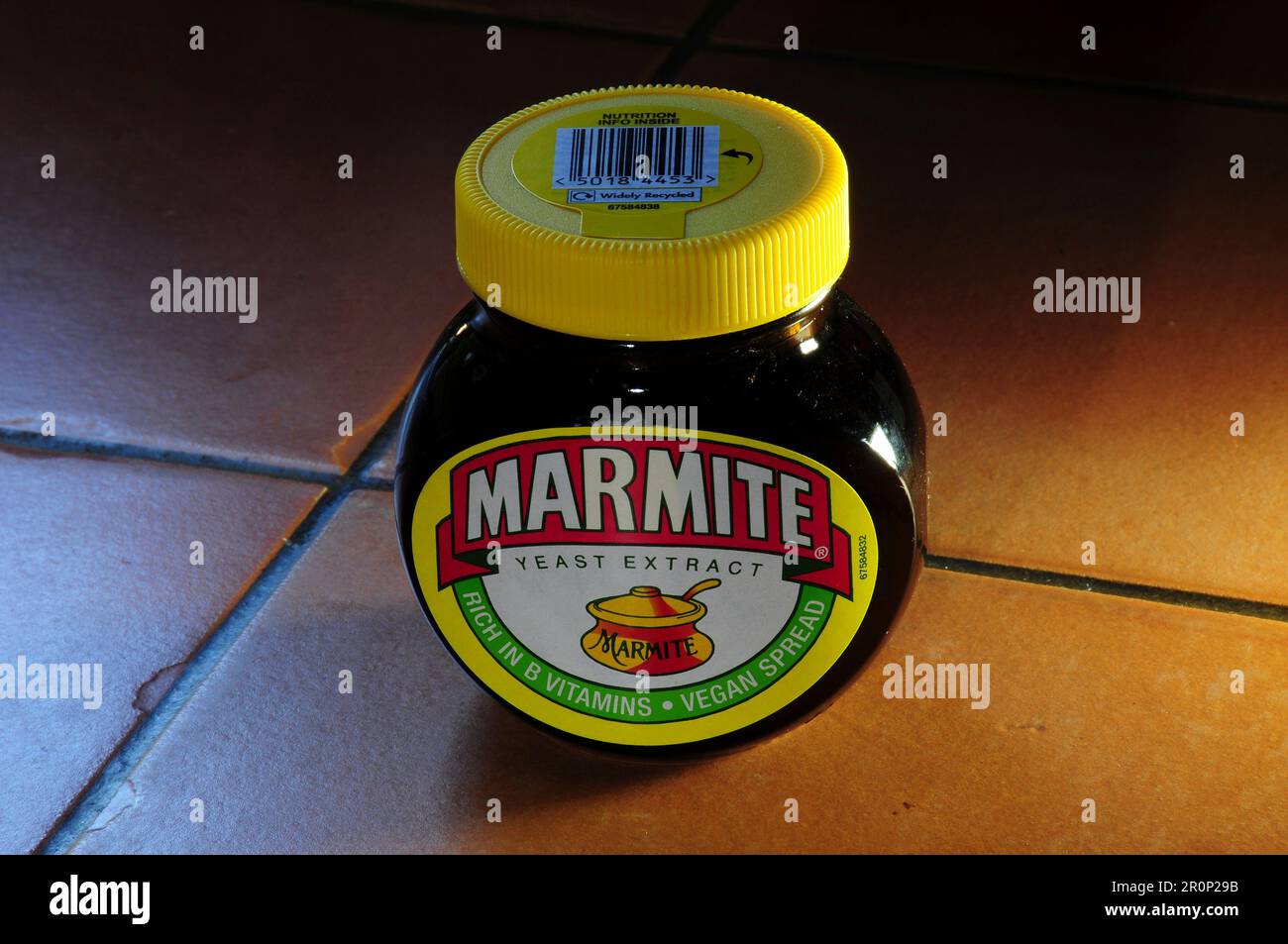 Marmite jar with yellow lid standing on tiled surface Stock Photo - Alamy