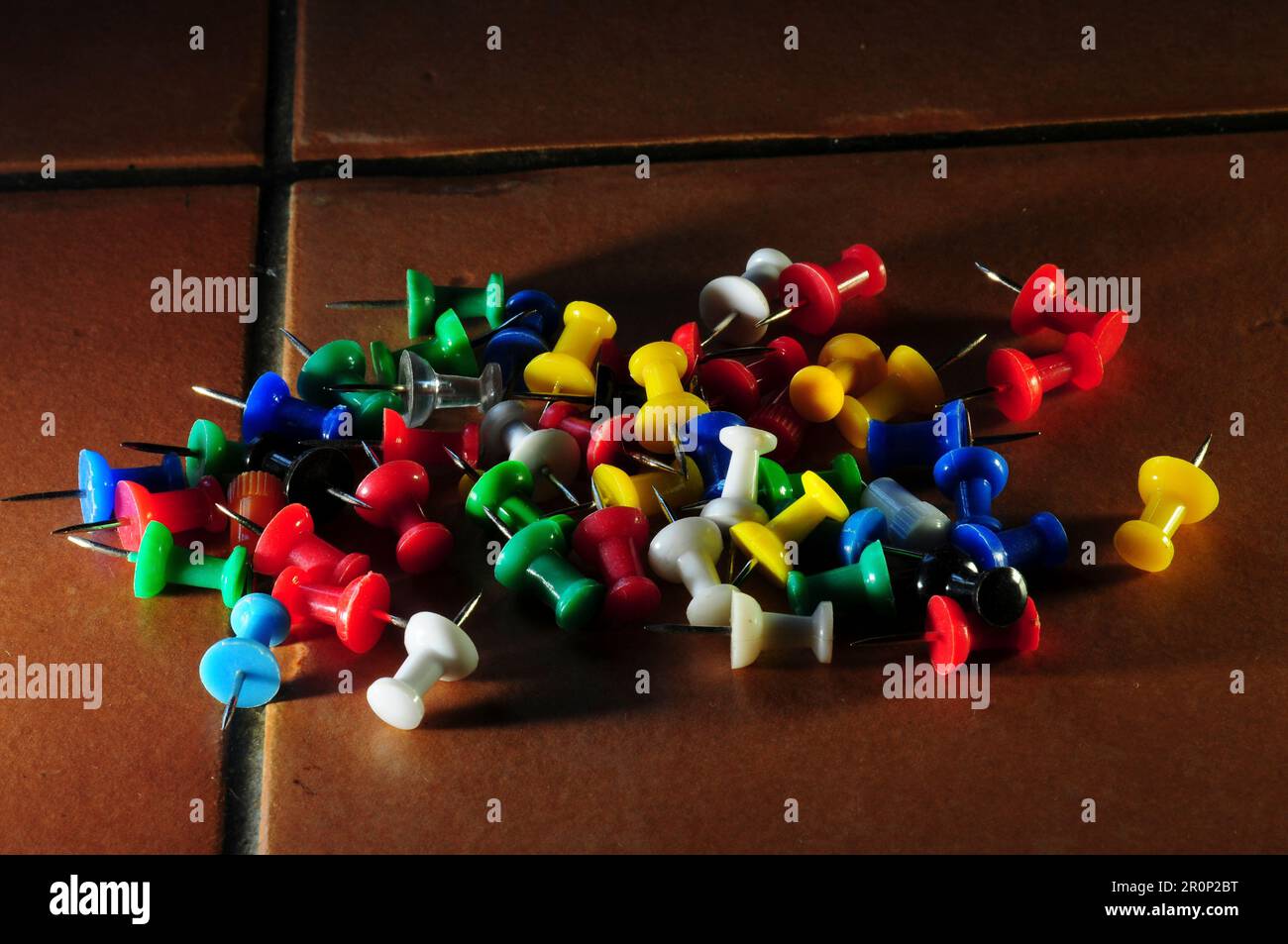 Plastic multi coloured map pins on tiled surface Stock Photo - Alamy