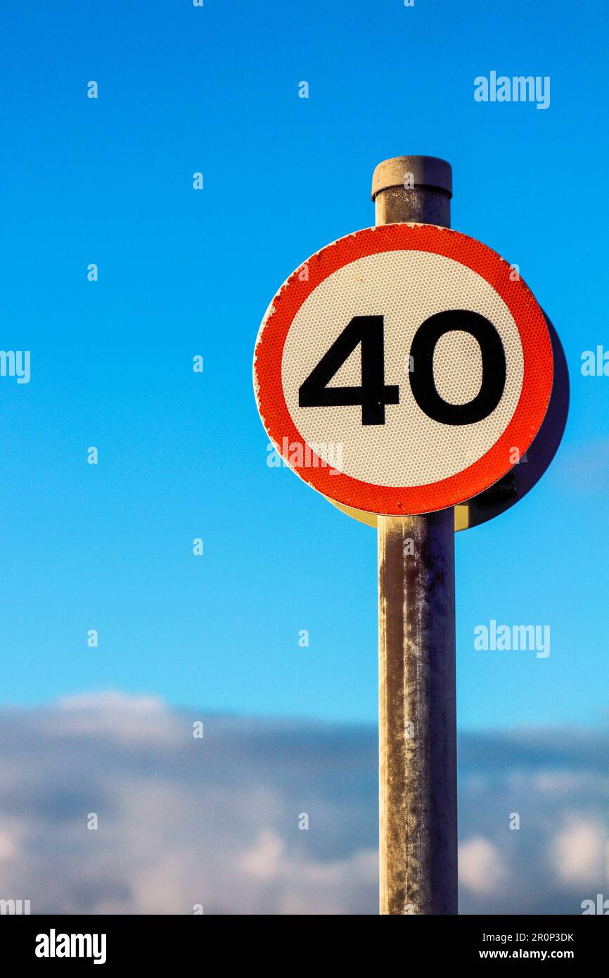 A metal speed limit sign with the number 40 displayed at the center of ...