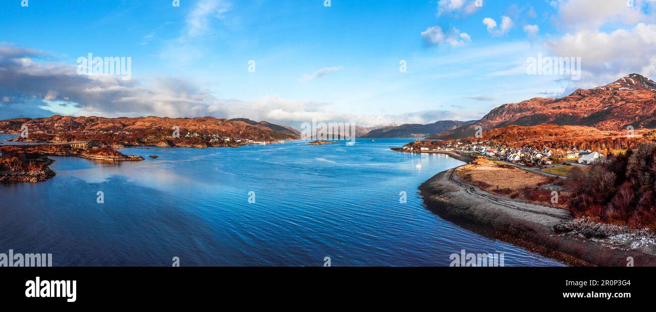 An aerial panoramic view of blue water with mountains on the shore in ...