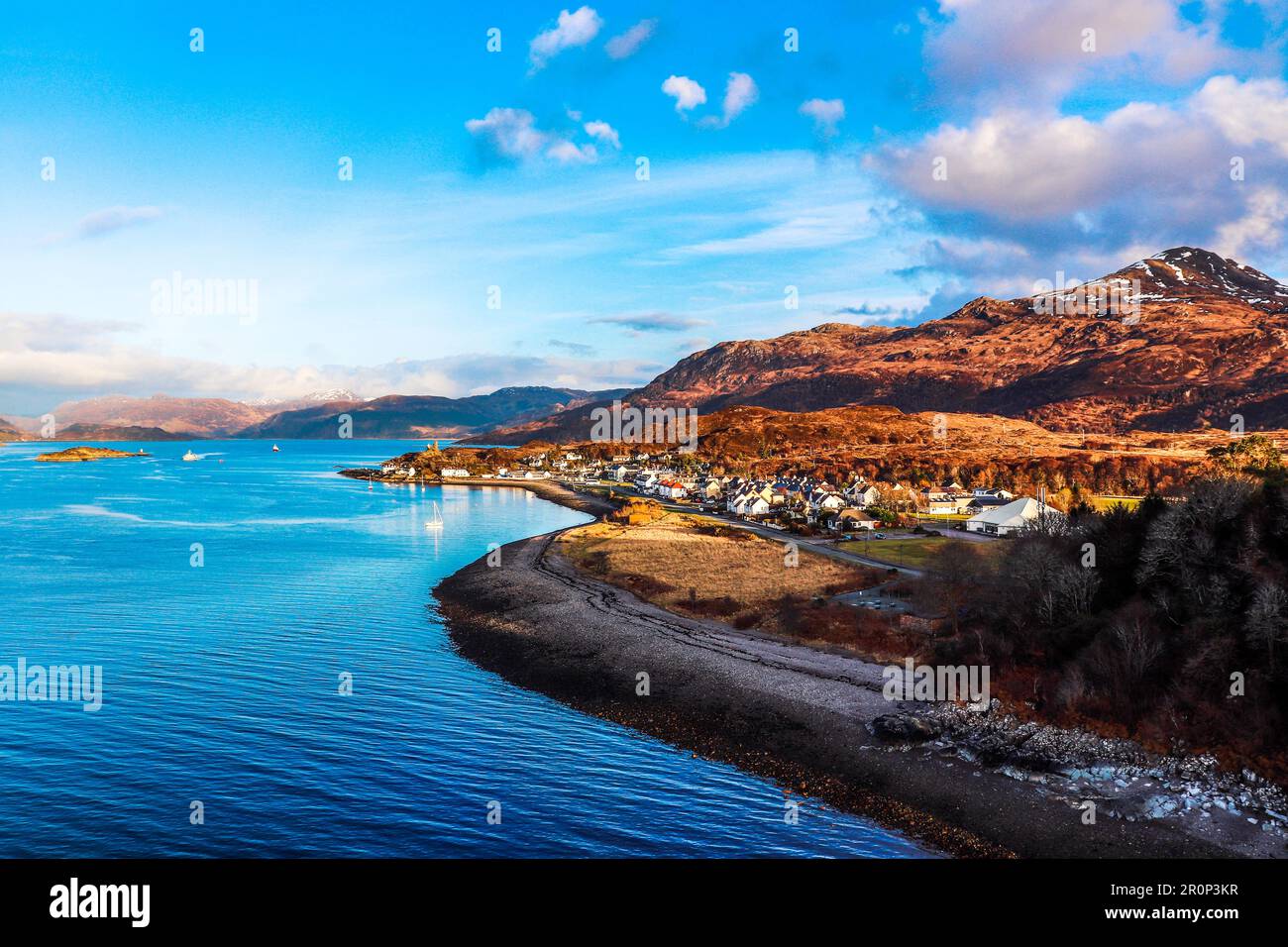 An aerial view of a vast body of water and a mountain range in Kyle of ...