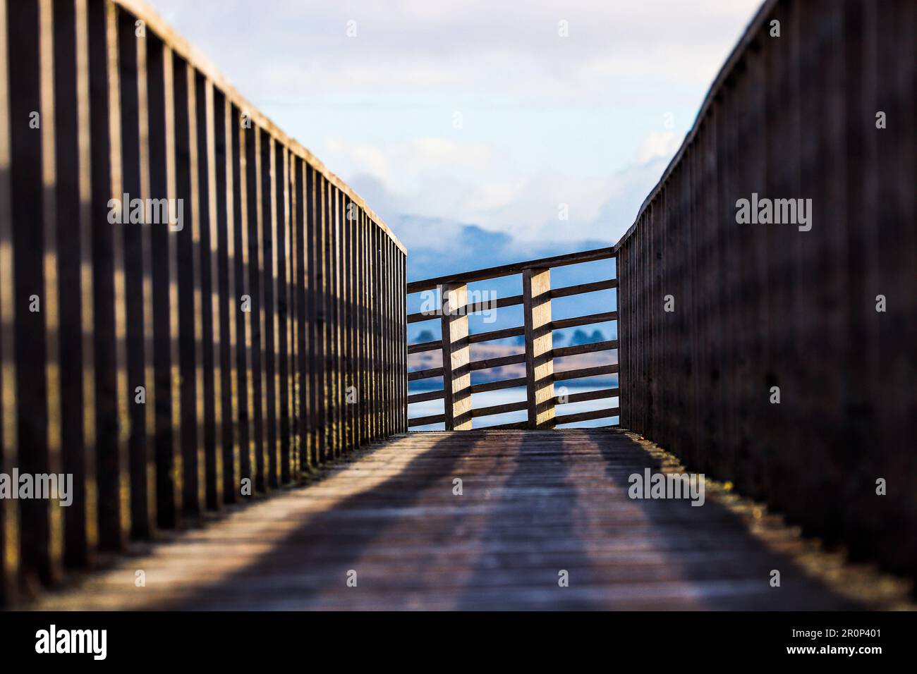 A wooden and metal bridge spans across a body of water in Isle of Skye ...