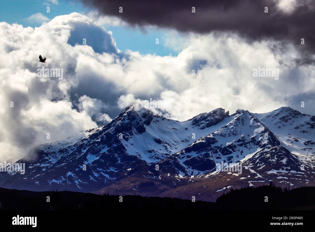 A scenic landscape featuring snowy mountains under a dramatic sky in ...