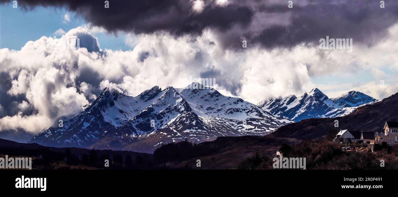 A scenic landscape featuring snowy mountains under a dramatic sky in ...