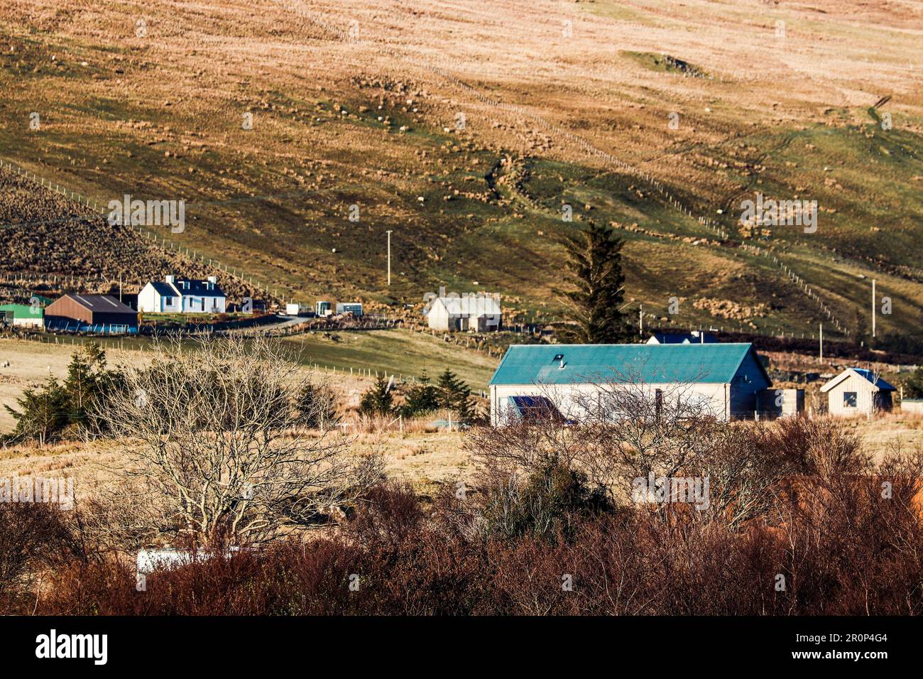 An aerial view of rural houses on a dry mountainside field in Isle of ...