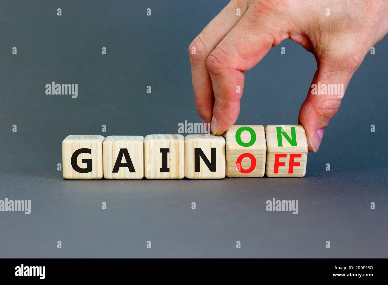Gain on or off symbol. Businessman turns wooden cubes and changes word ...
