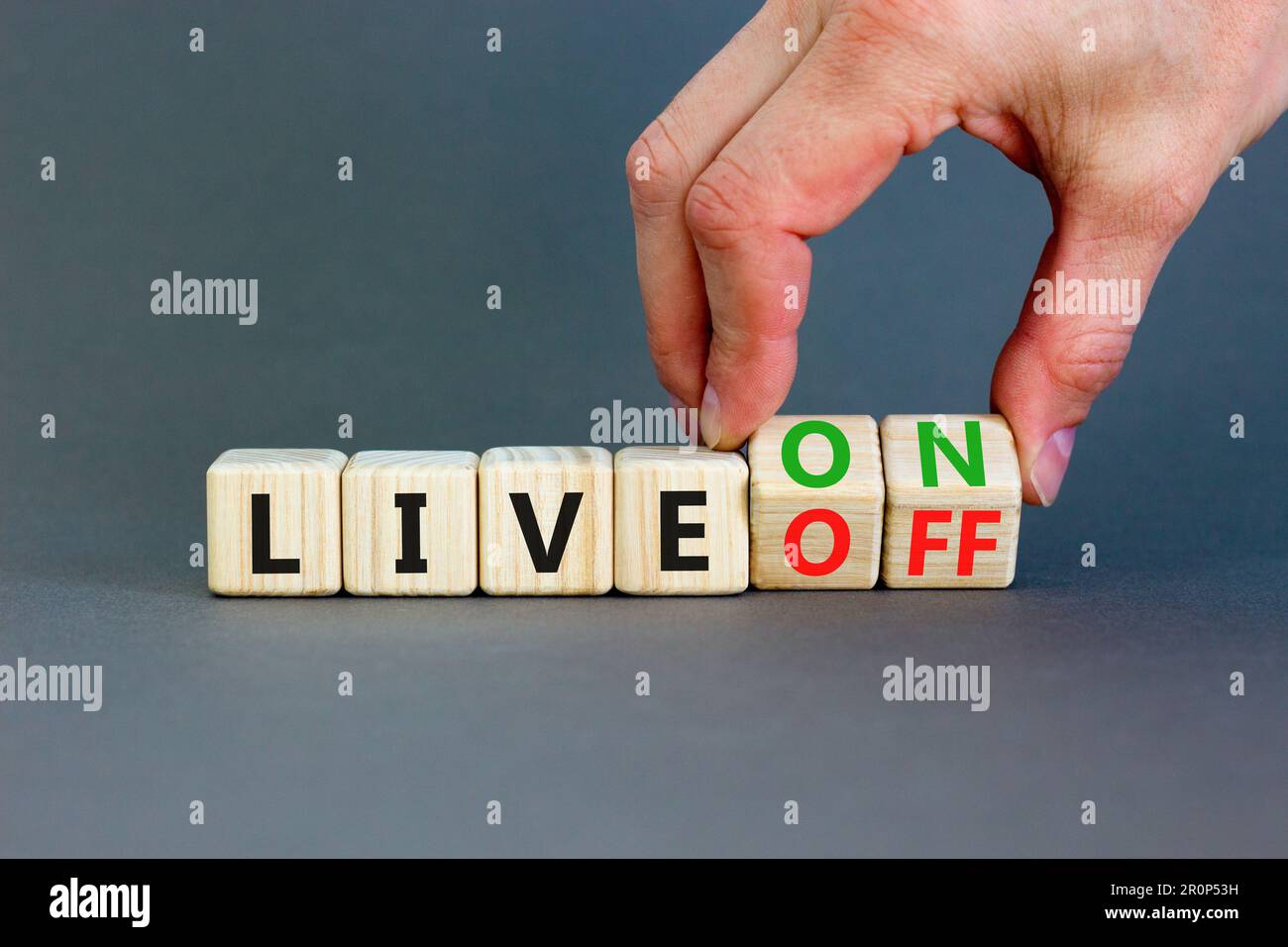 Live on or off symbol. Businessman turns wooden cubes and changes word ...