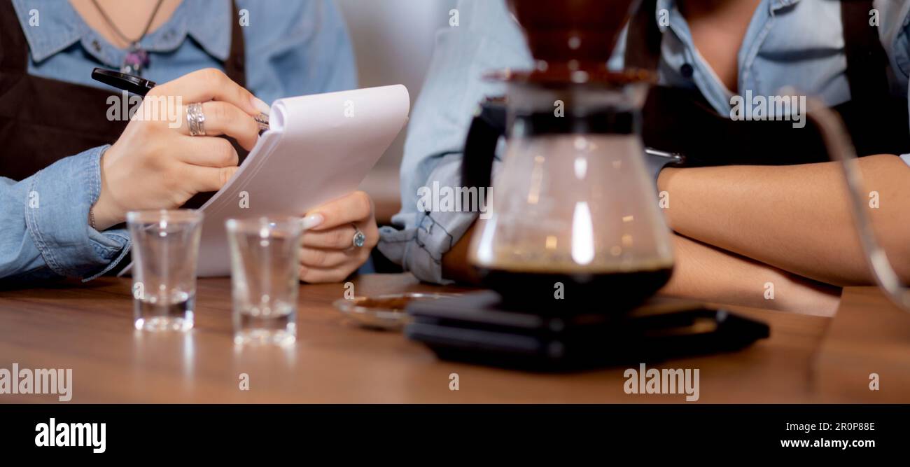 Young man and woman learning making coffee with barista while pouring ...
