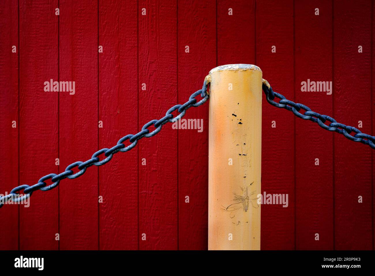 Chains and yellow post for protection and security with red background ...