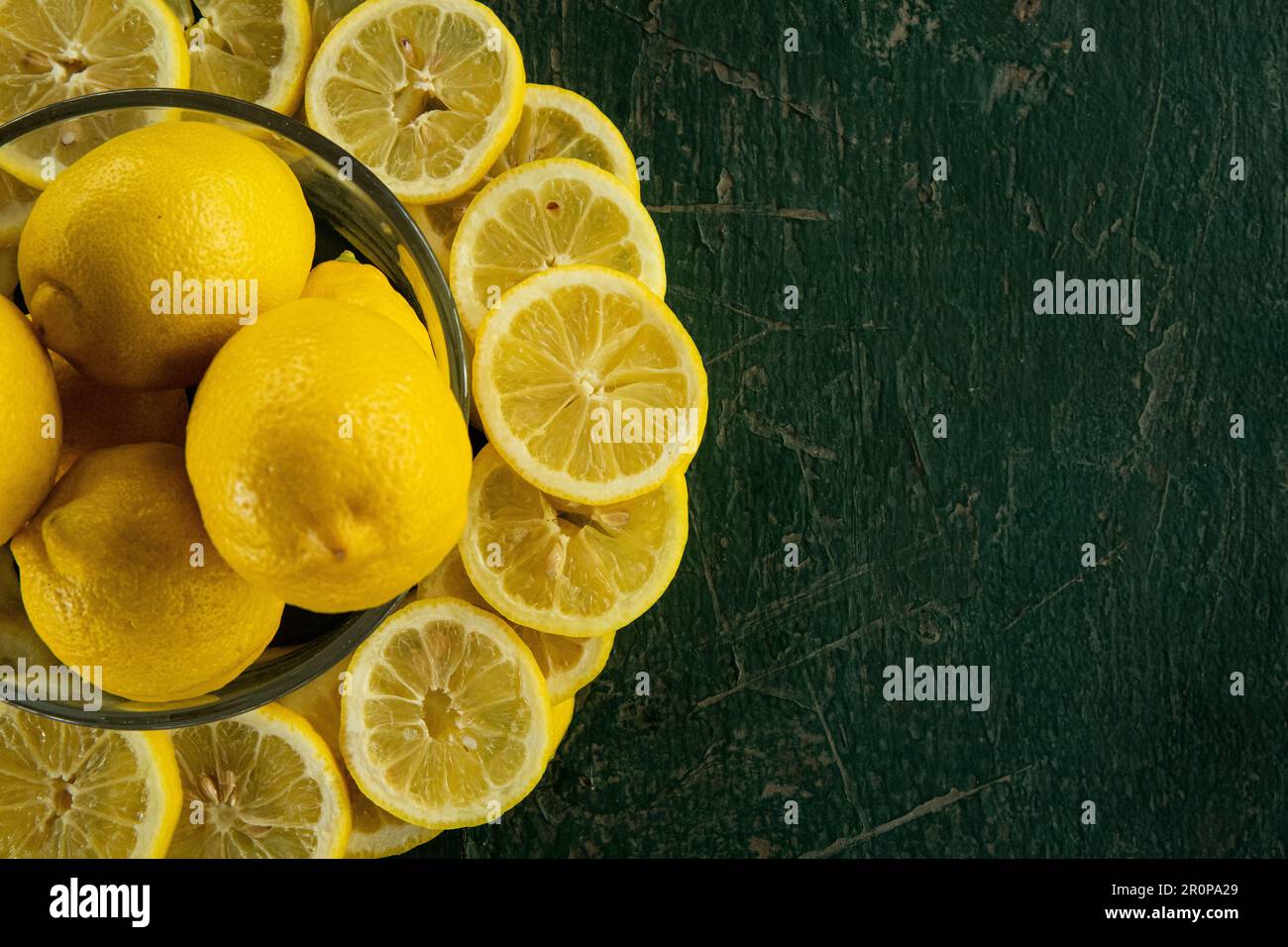 whole and sliced lemons arranged in a circular pattern on a green ...