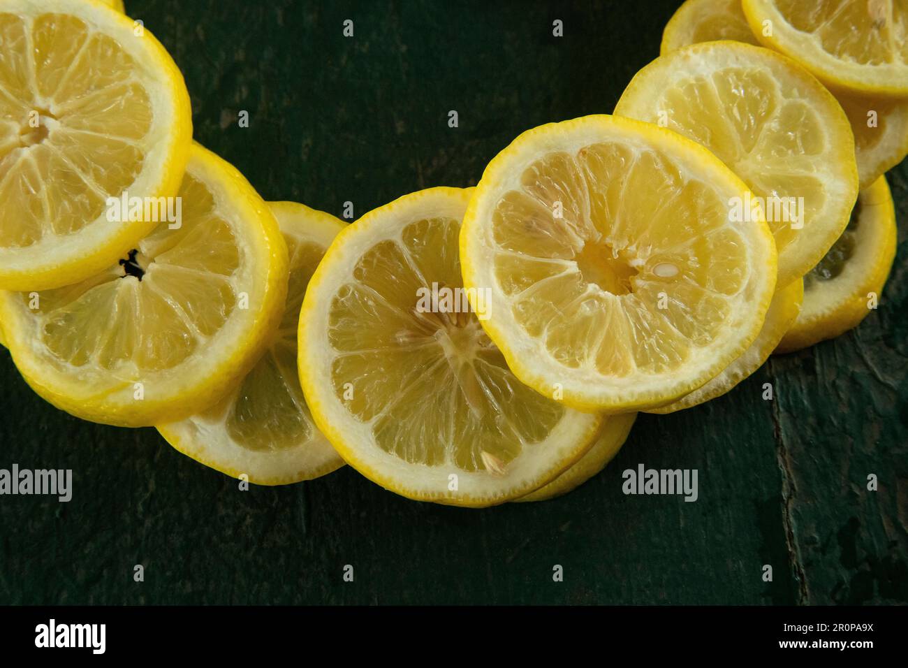 whole and sliced lemons arranged in a circular pattern on a green ...