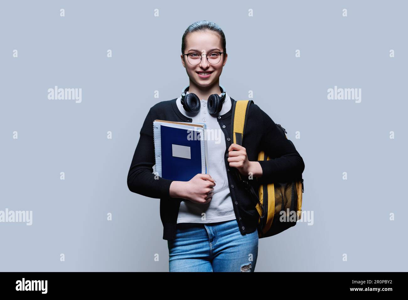 Portrait of teen girl high school student on grey studio background ...