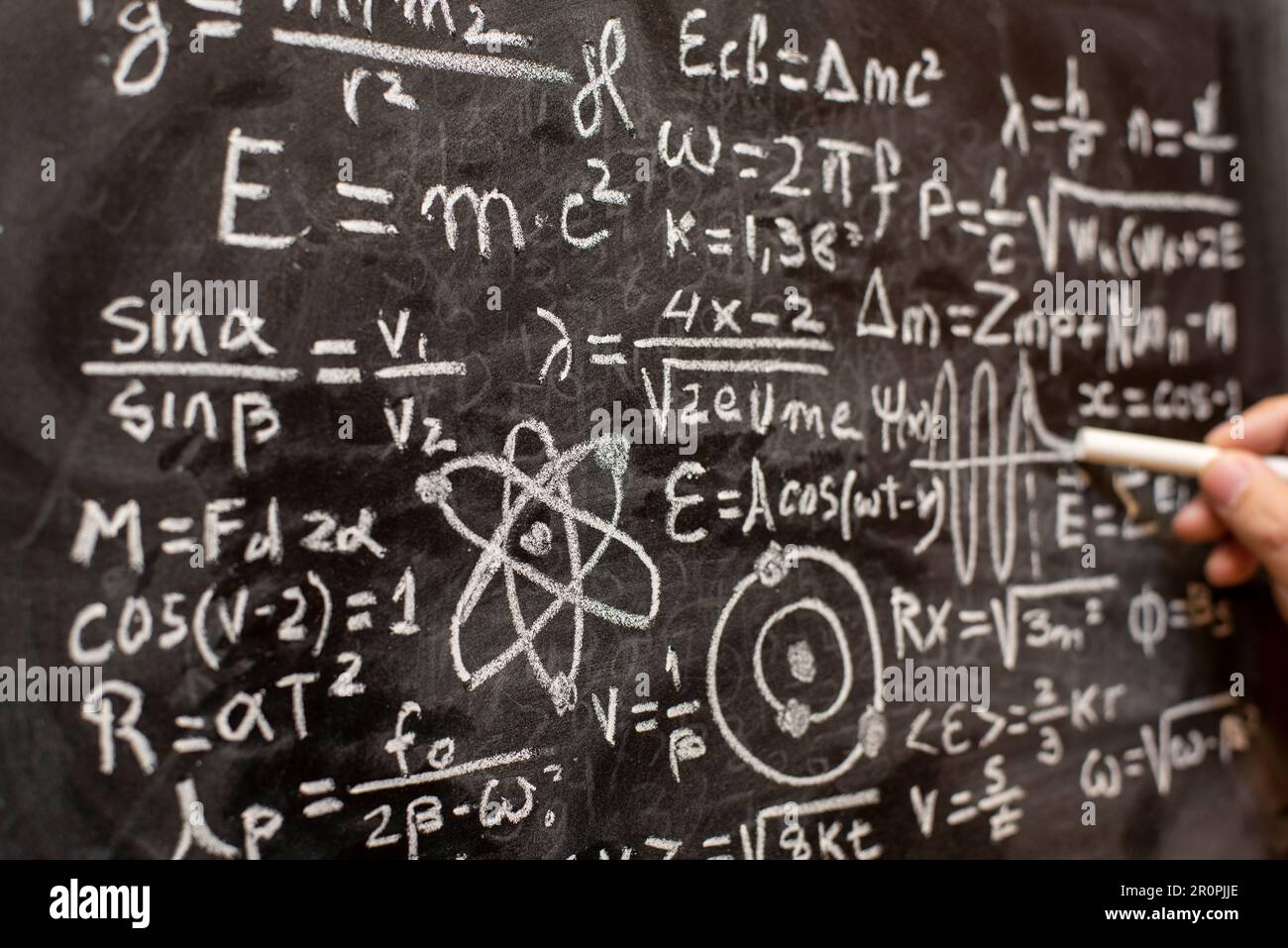 Operaciones y formulas de física cuántica escritas a mano con una tiza ...