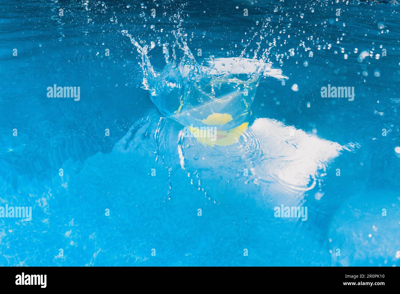 Yellow rubber duck plunging into swimming pool water with a big splash ...
