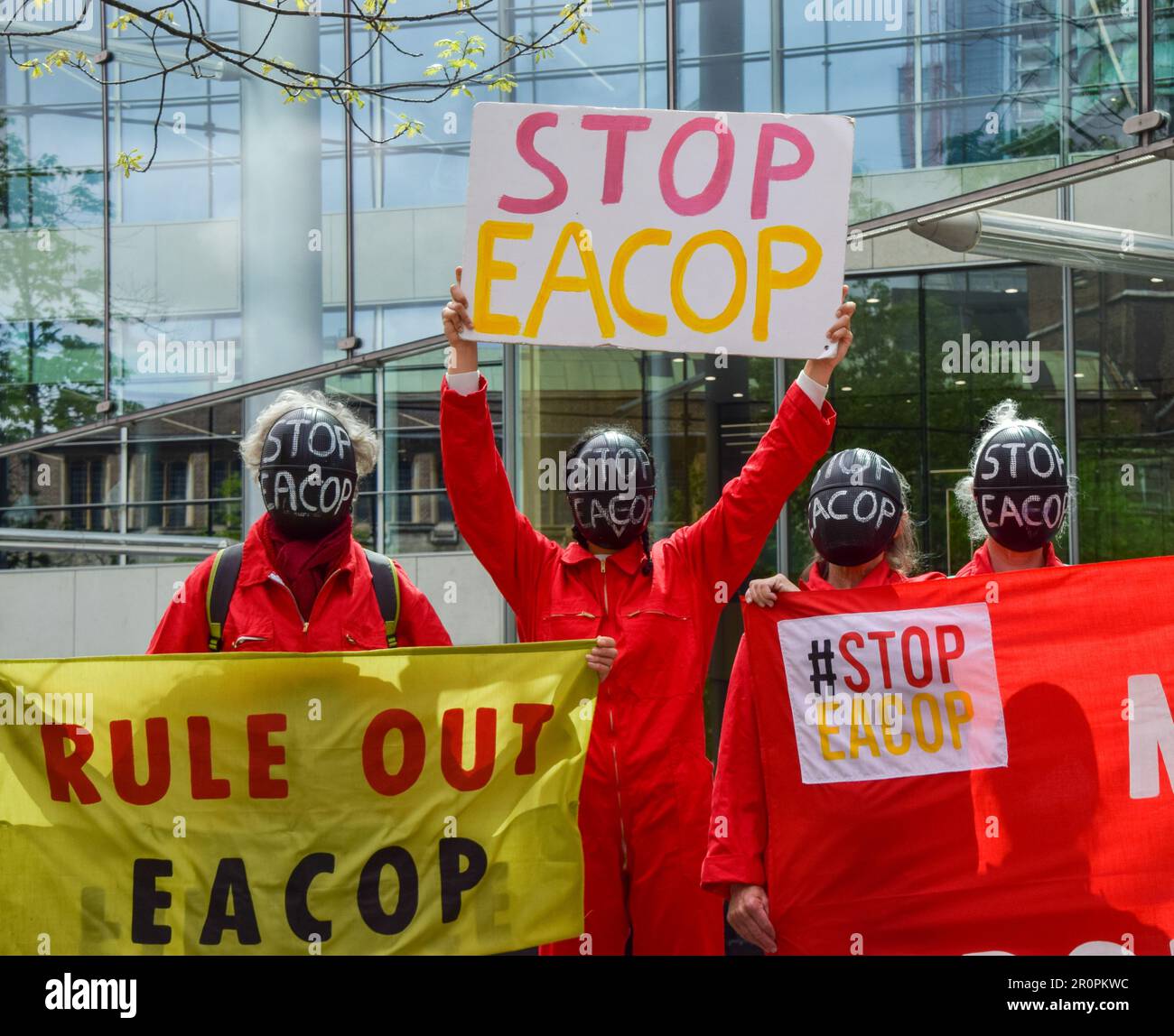 London, UK. 09th May, 2023. Activists wearing 'Stop EACOP' masks hold ...