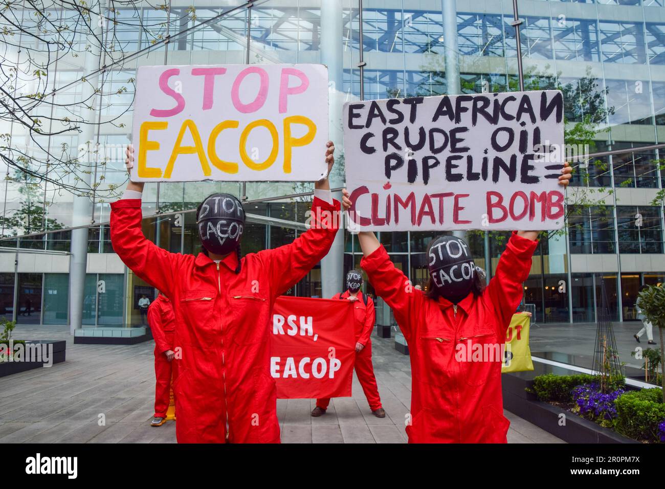 London, UK. 09th May, 2023. Activists wearing 'Stop EACOP' masks hold ...