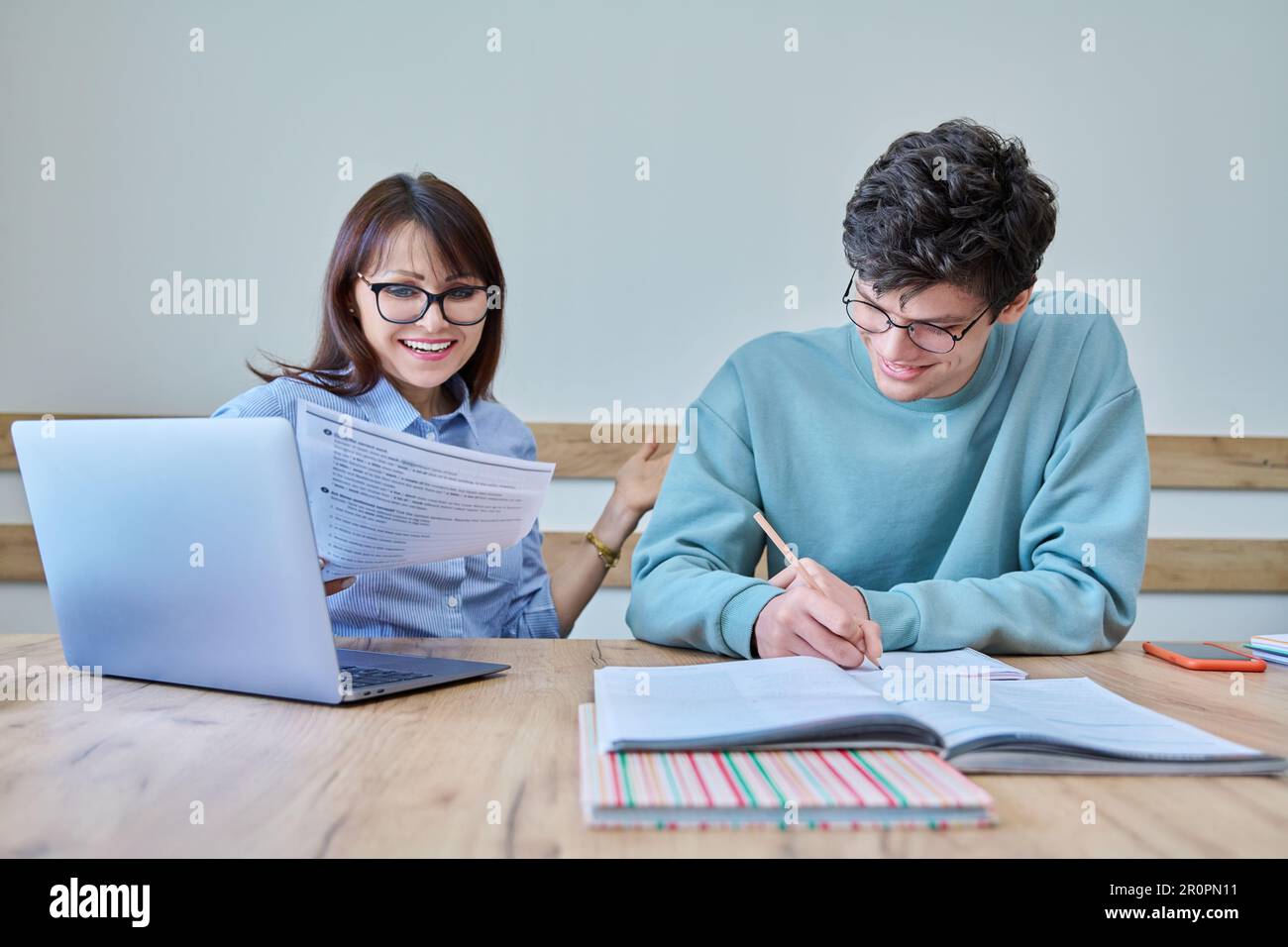 Young teenage male studying languages with teacher in classroom Stock ...