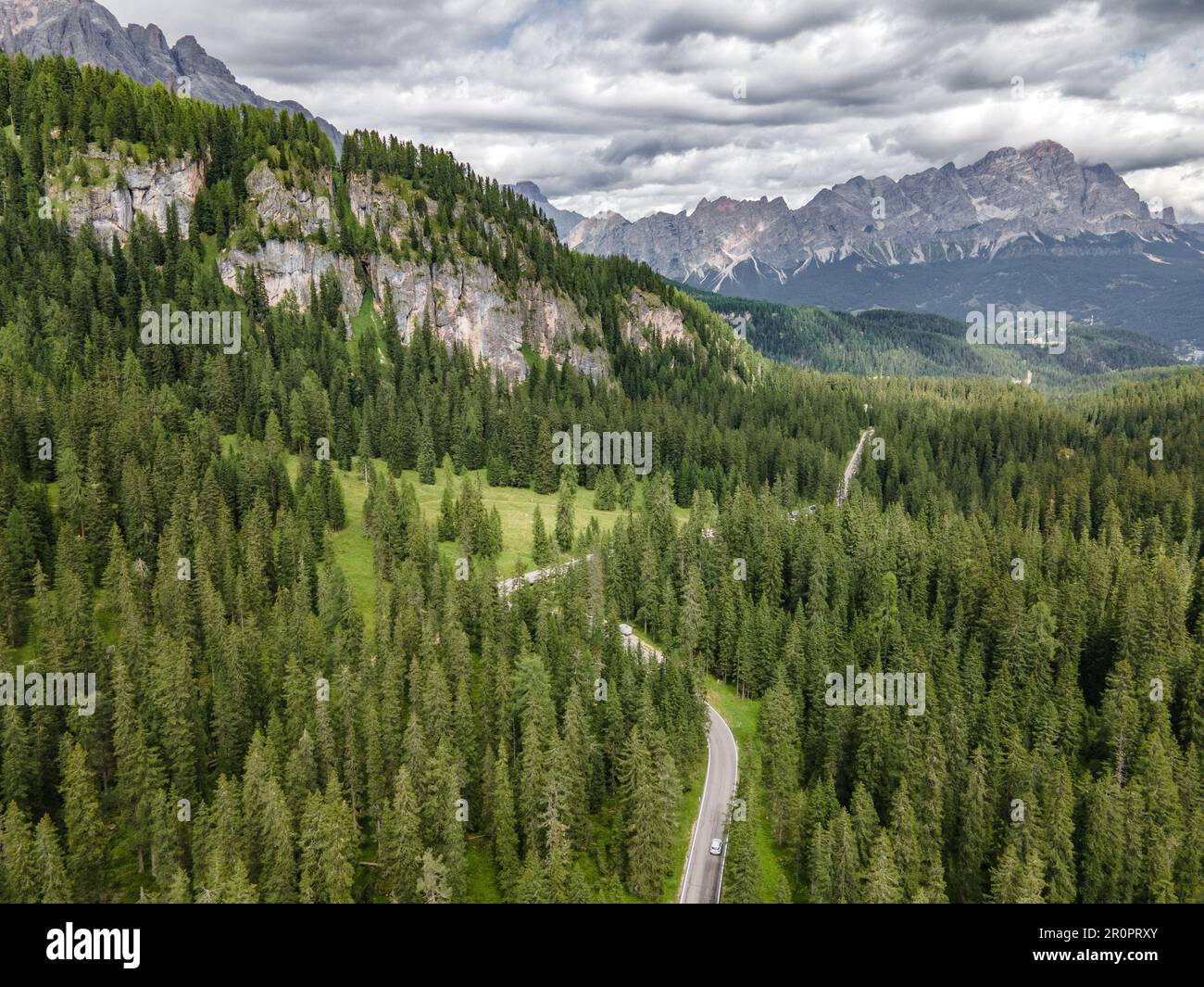 Aerial shot of a curvy road in a forest near the giau pass in the ...