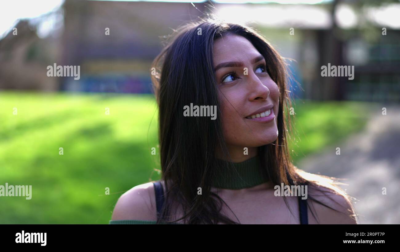 One hopeful Arab adult girl looking up at sky with Faithful gaze. Closeup face of a young happy ...