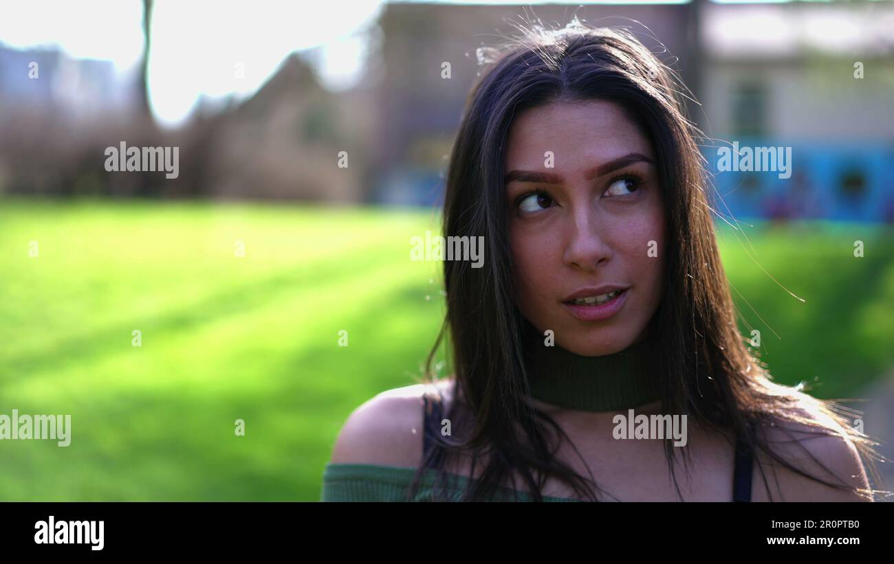One hopeful Arab adult girl looking up at sky with Faithful gaze. Closeup face of a young happy ...