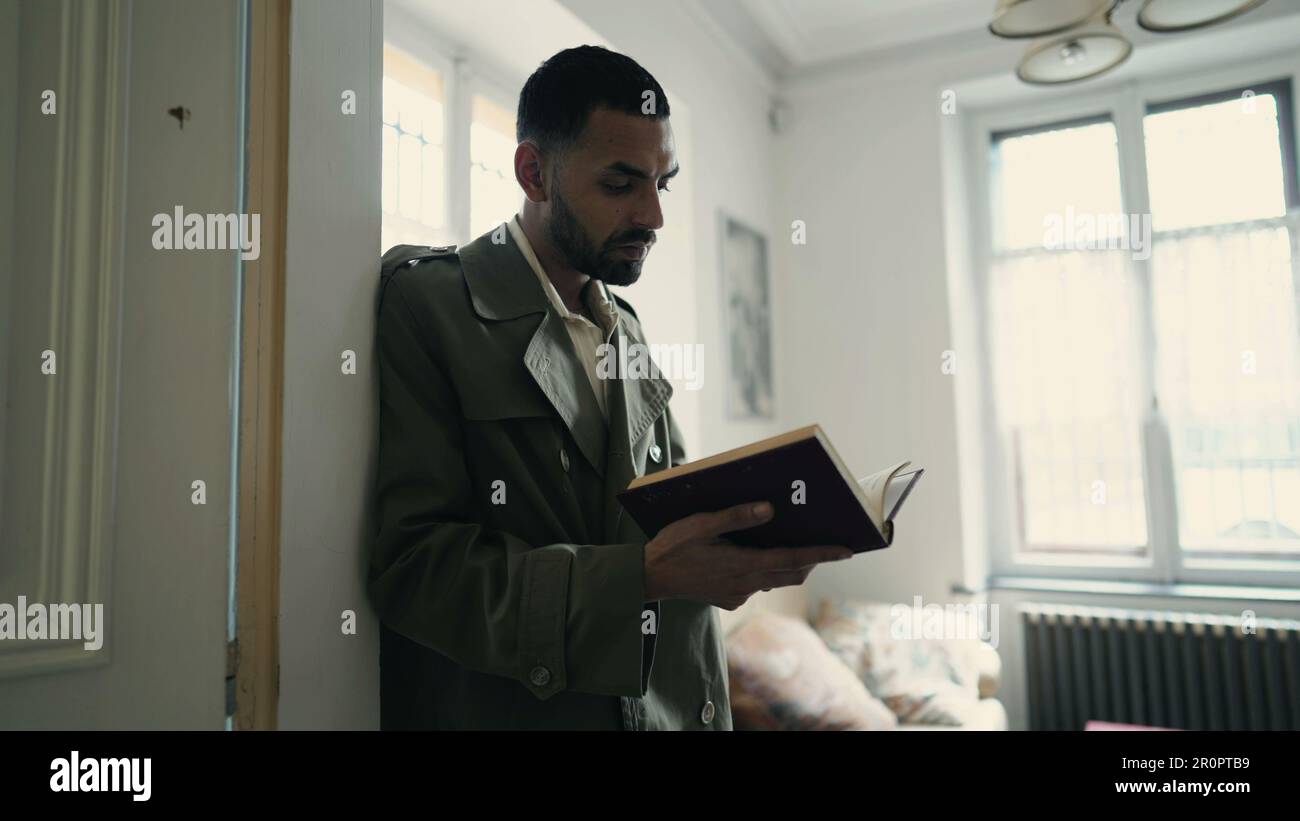 One Middle Eastern man reads a book indoors. A focused Arab guy ...